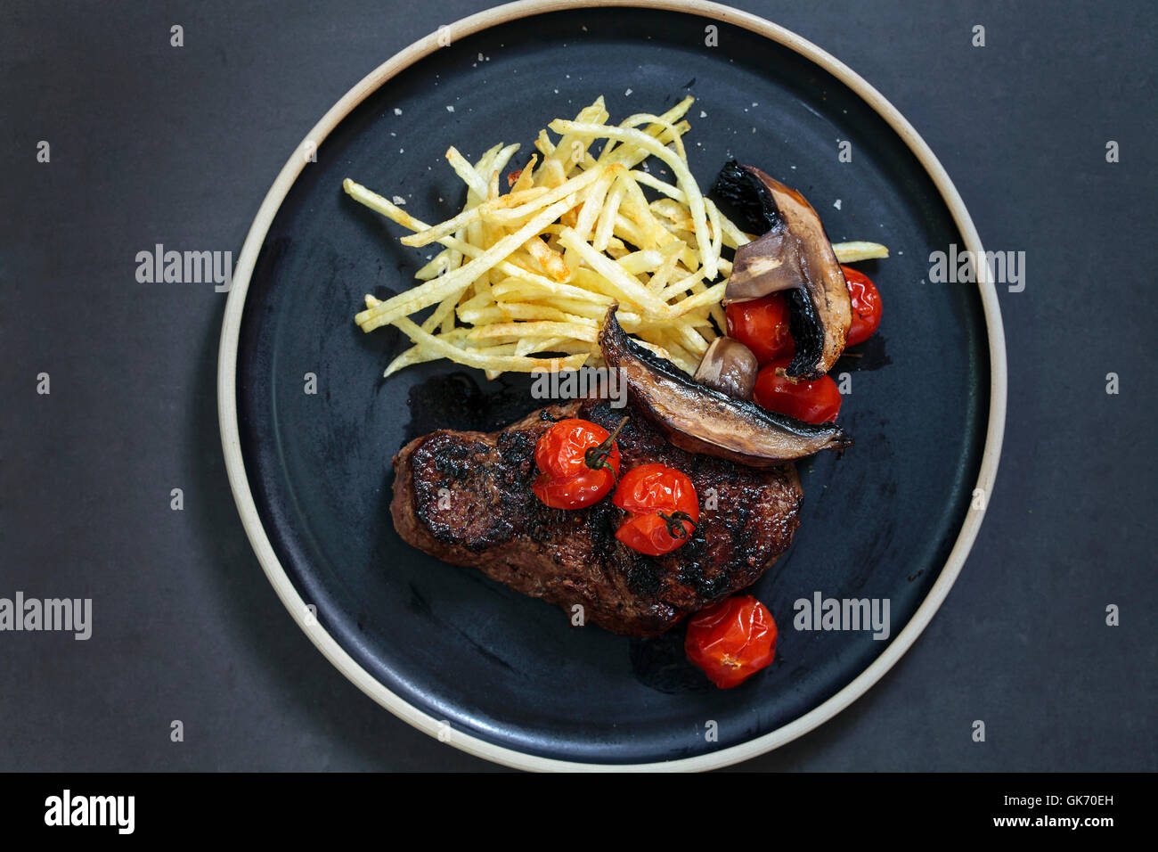 Fillet steak with string fries, roast tomatoes and portobello mushrooms ...