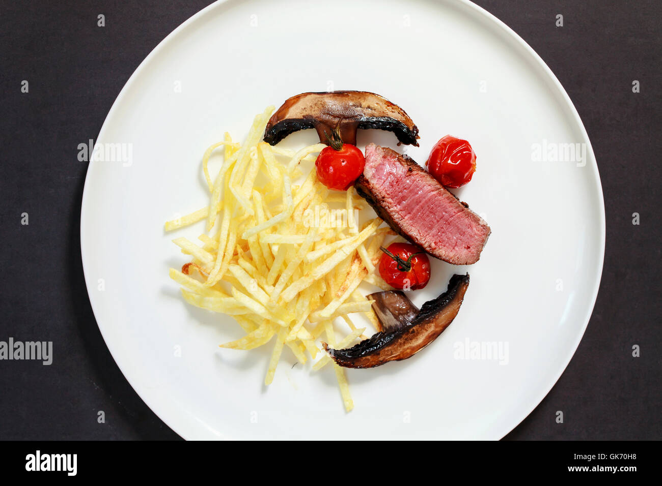Fillet steak with string fries, roast tomatoes and portobello mushrooms ...