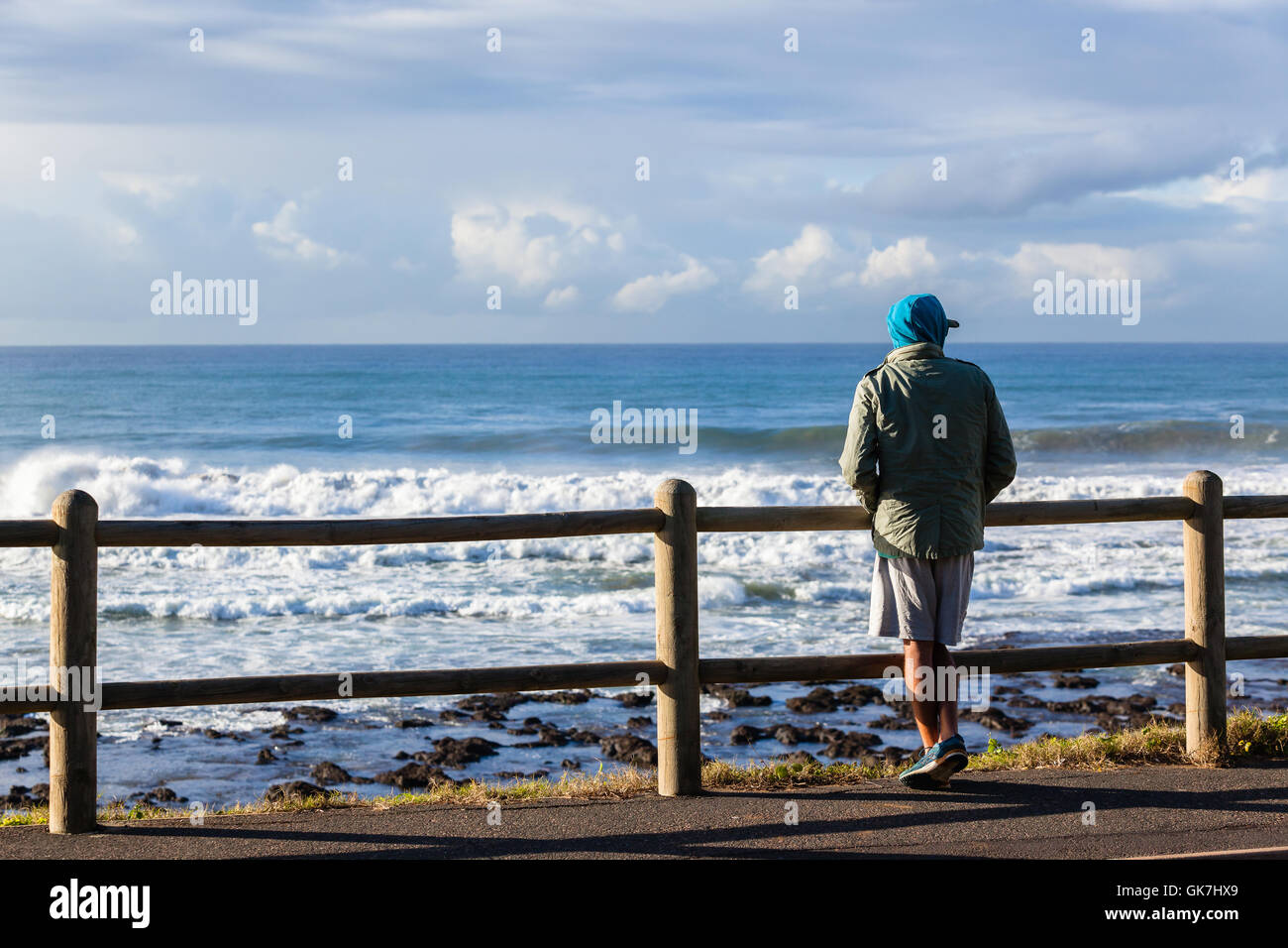 Man unidentified looking out over ocean waves along beach rocky ...