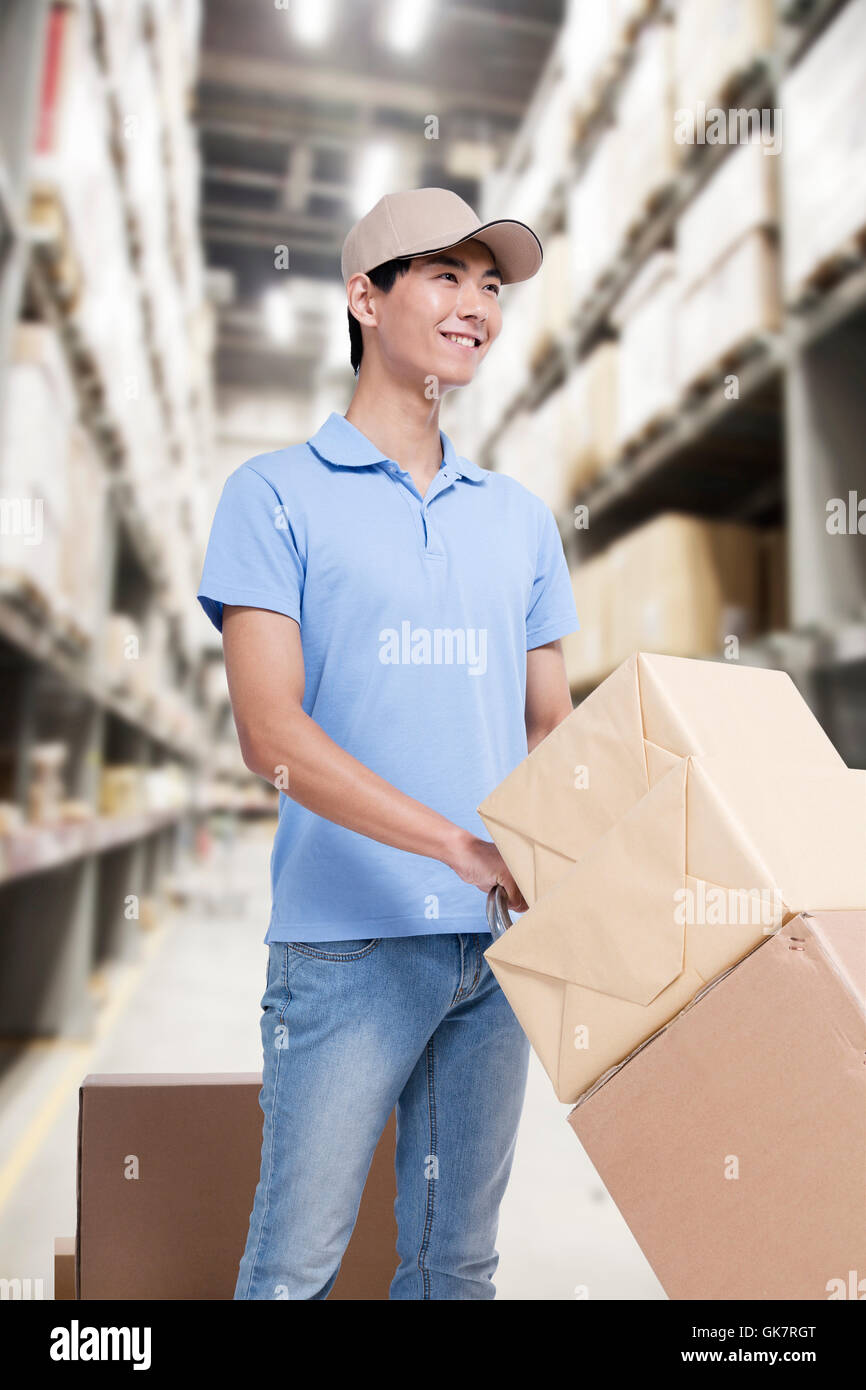 Logistics warehouse staff push carts carrying goods Stock Photo - Alamy