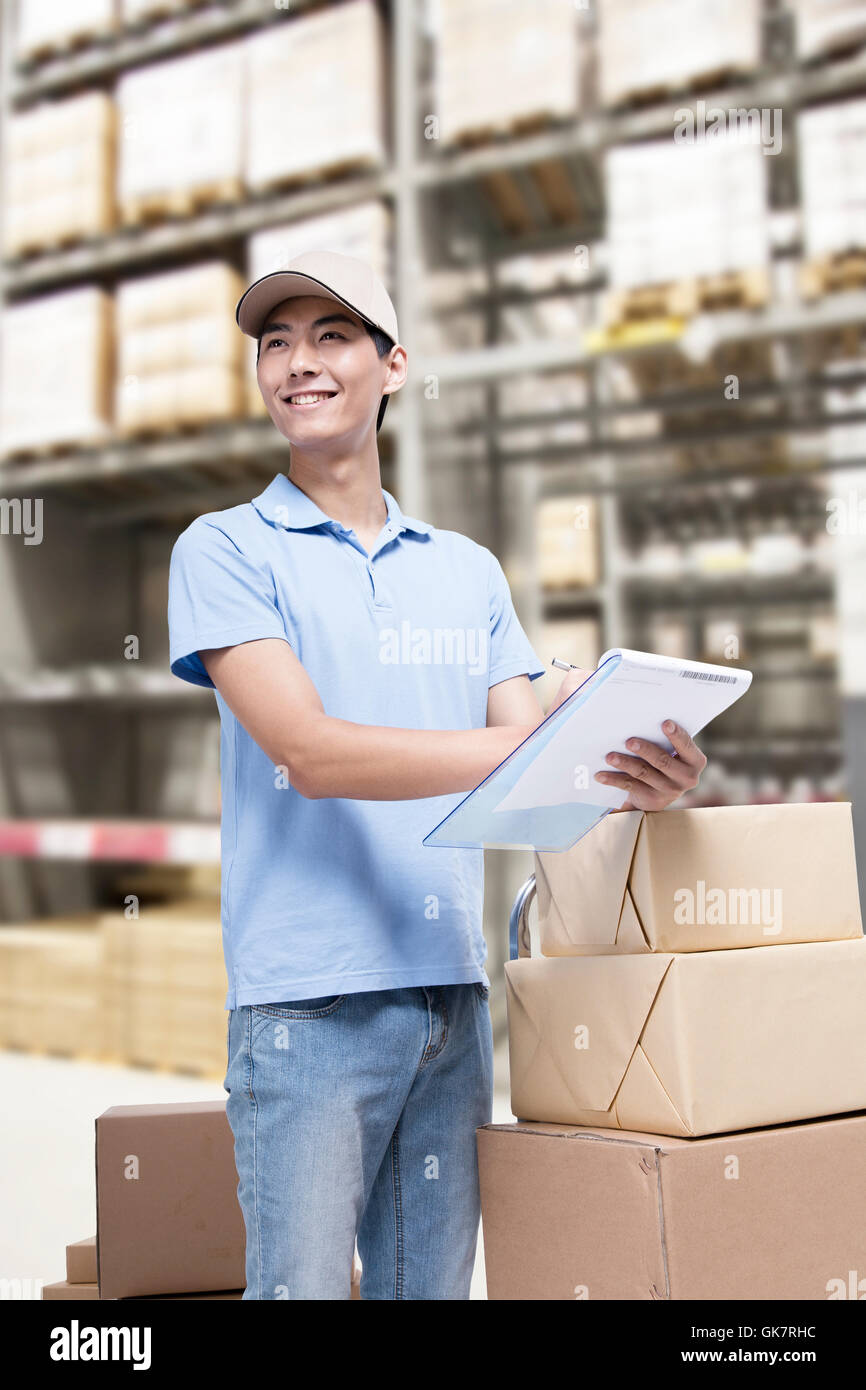 Logistics warehouse staff push carts carrying goods Stock Photo - Alamy