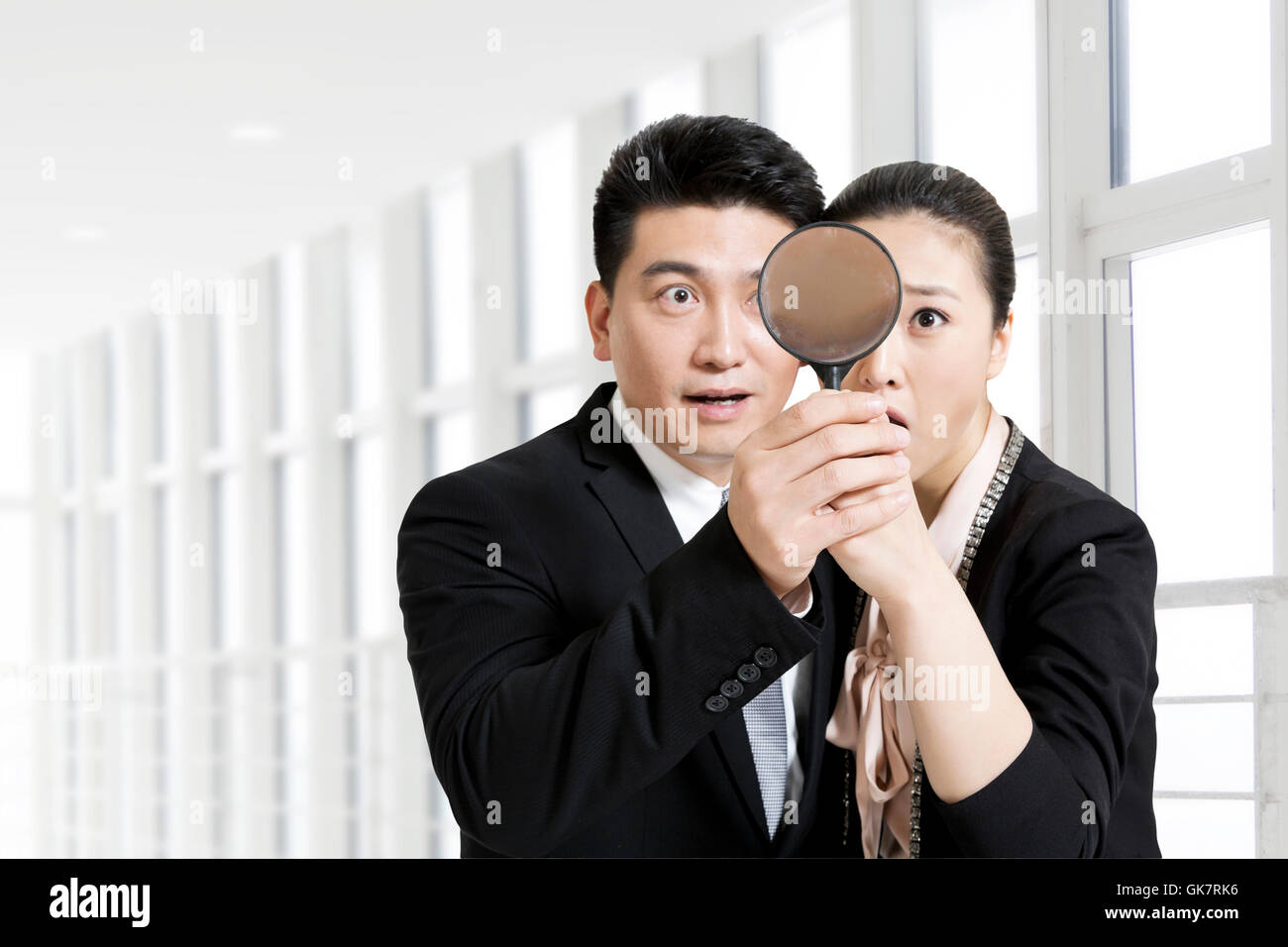 Business people holding a magnifying glass Stock Photo - Alamy