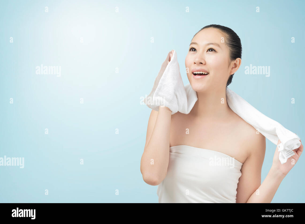 Studio shot a young woman holding a white towel to wipe Stock Photo - Alamy