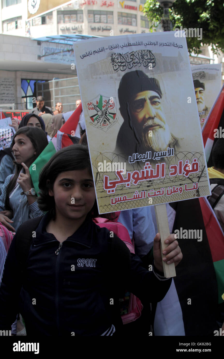 West Bank, Palestine. 18th Aug, 2016. Palestinians hold pictures of ...