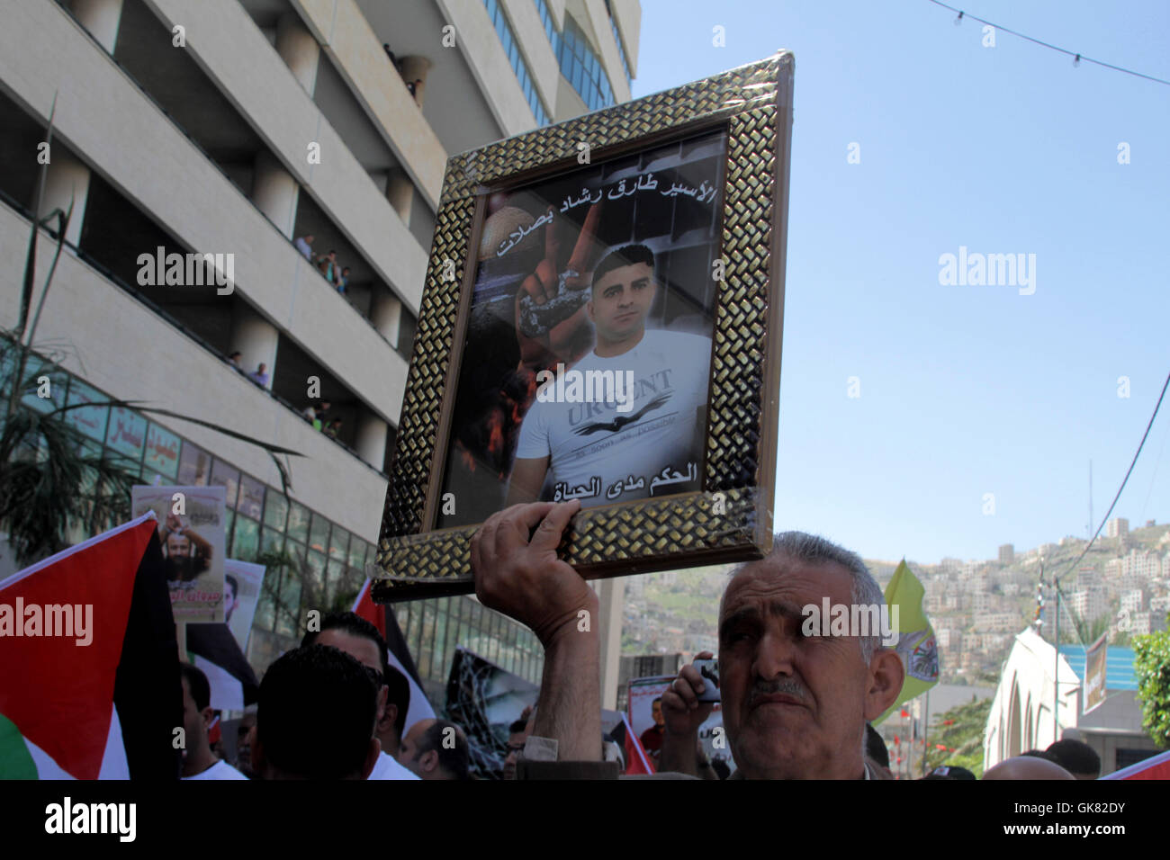 West Bank, Palestine. 18th Aug, 2016. Palestinians hold pictures of ...