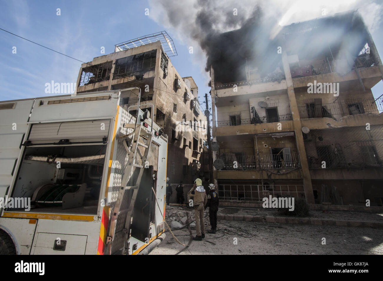 Aleppo, Syria. 23rd Apr, 2016. People watch as a civilian building is ...