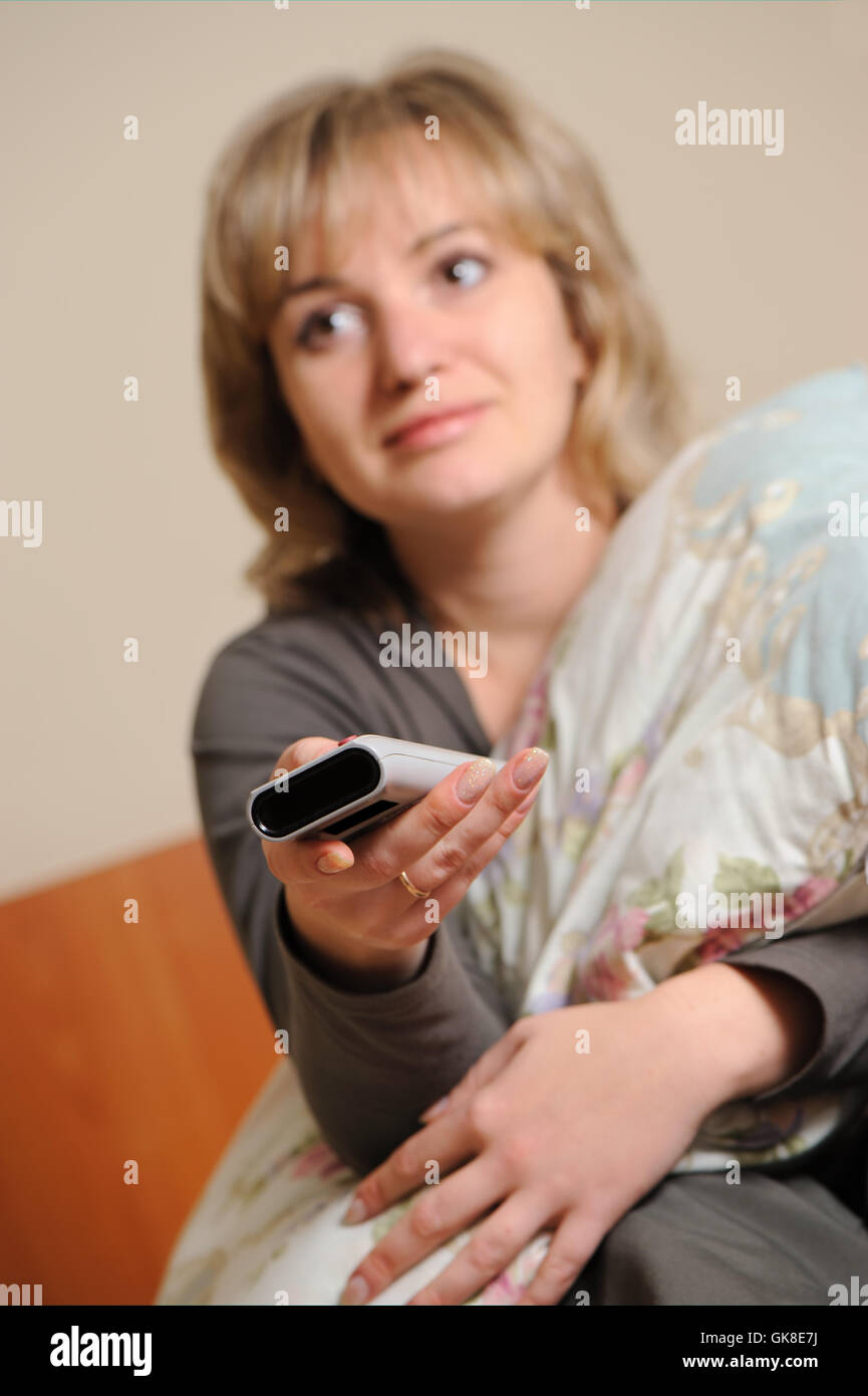 The woman with a television control panel. Selective focus Stock Photo ...