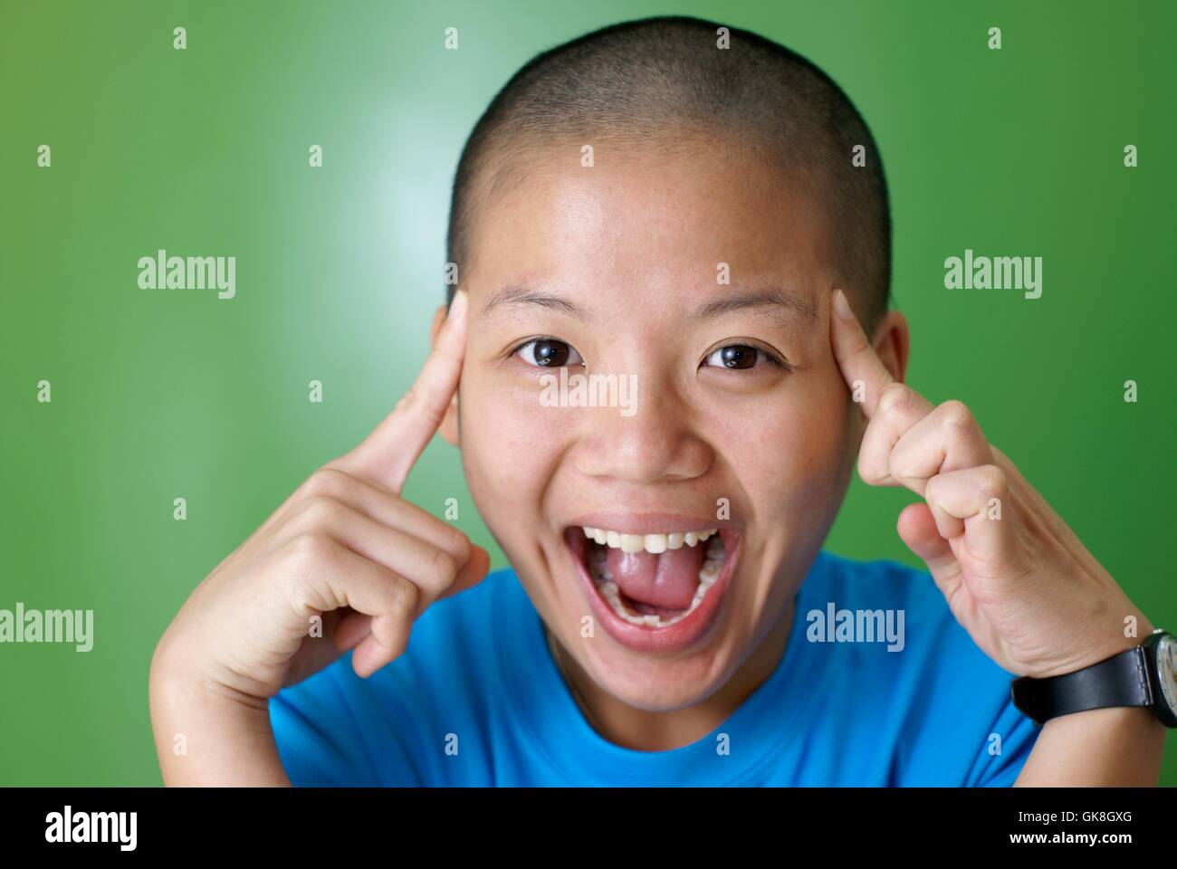 Happy bald asian lady point to head Stock Photo - Alamy