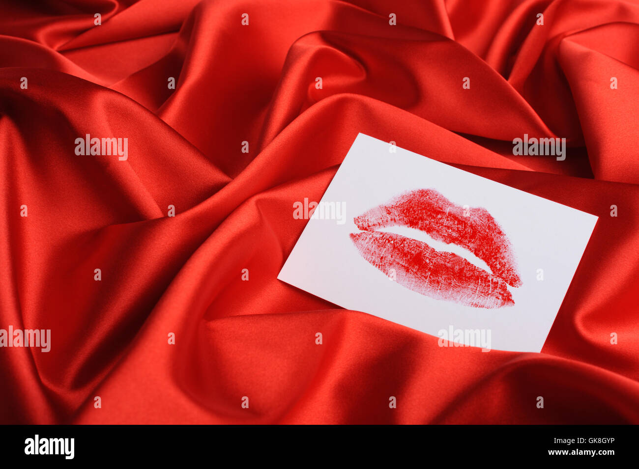 Note on red silk. A print of lips Stock Photo - Alamy