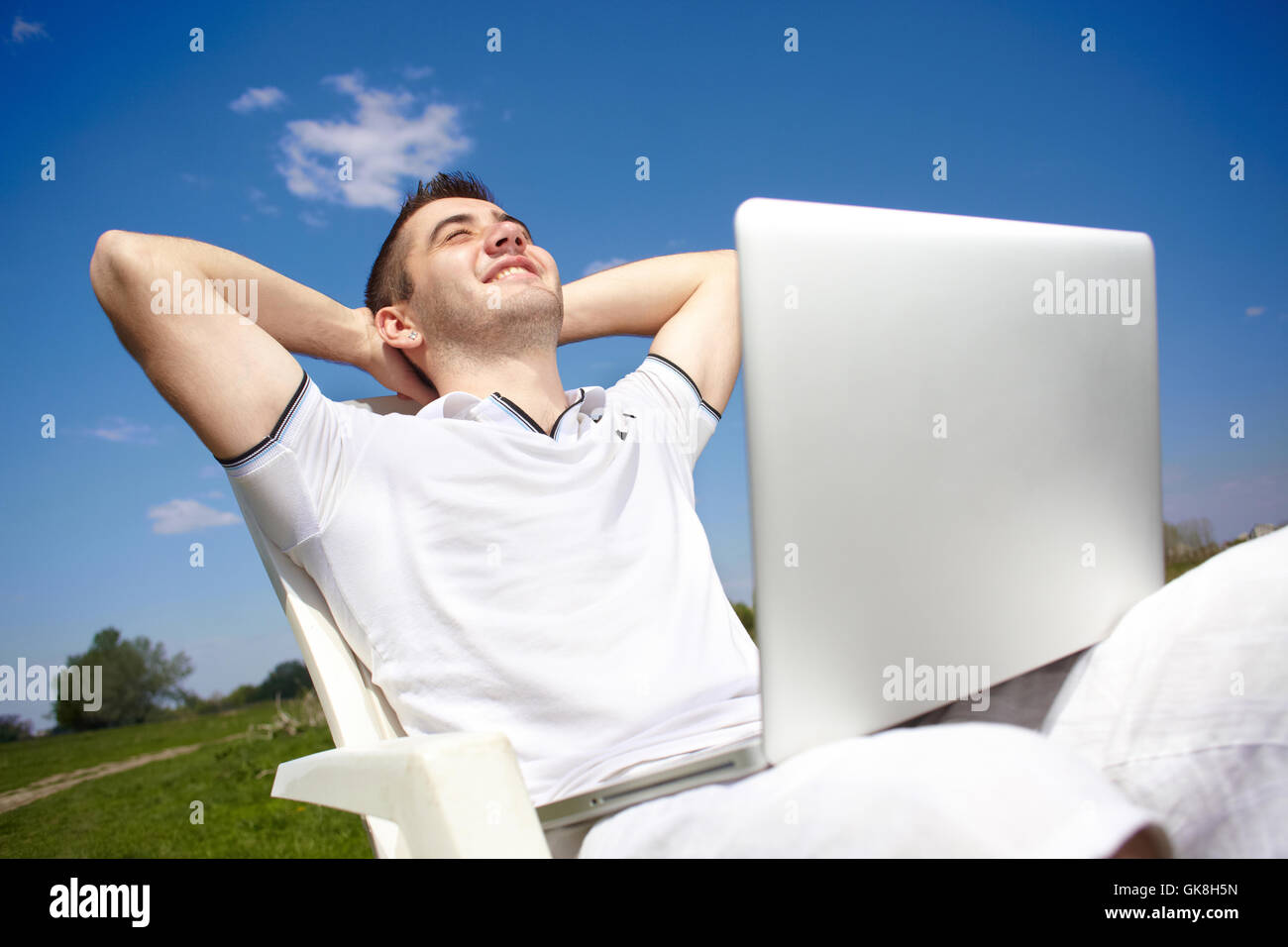 Happy young man working in the field. Beautiful summer sky Stock Photo ...