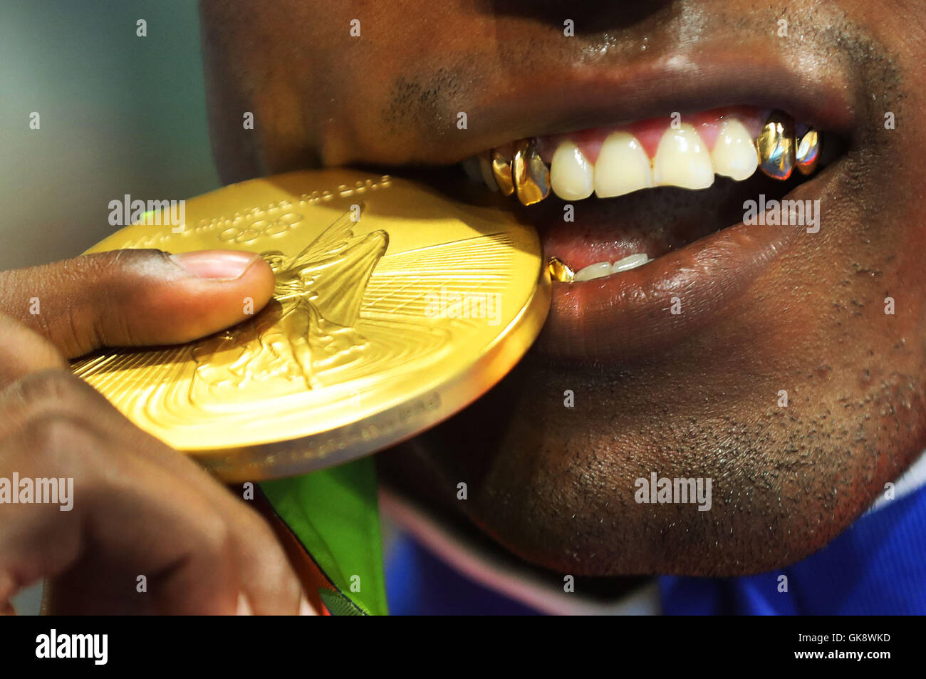 Cuba's Julio C"©sar La Cruz bites his gold medal following his win in ...