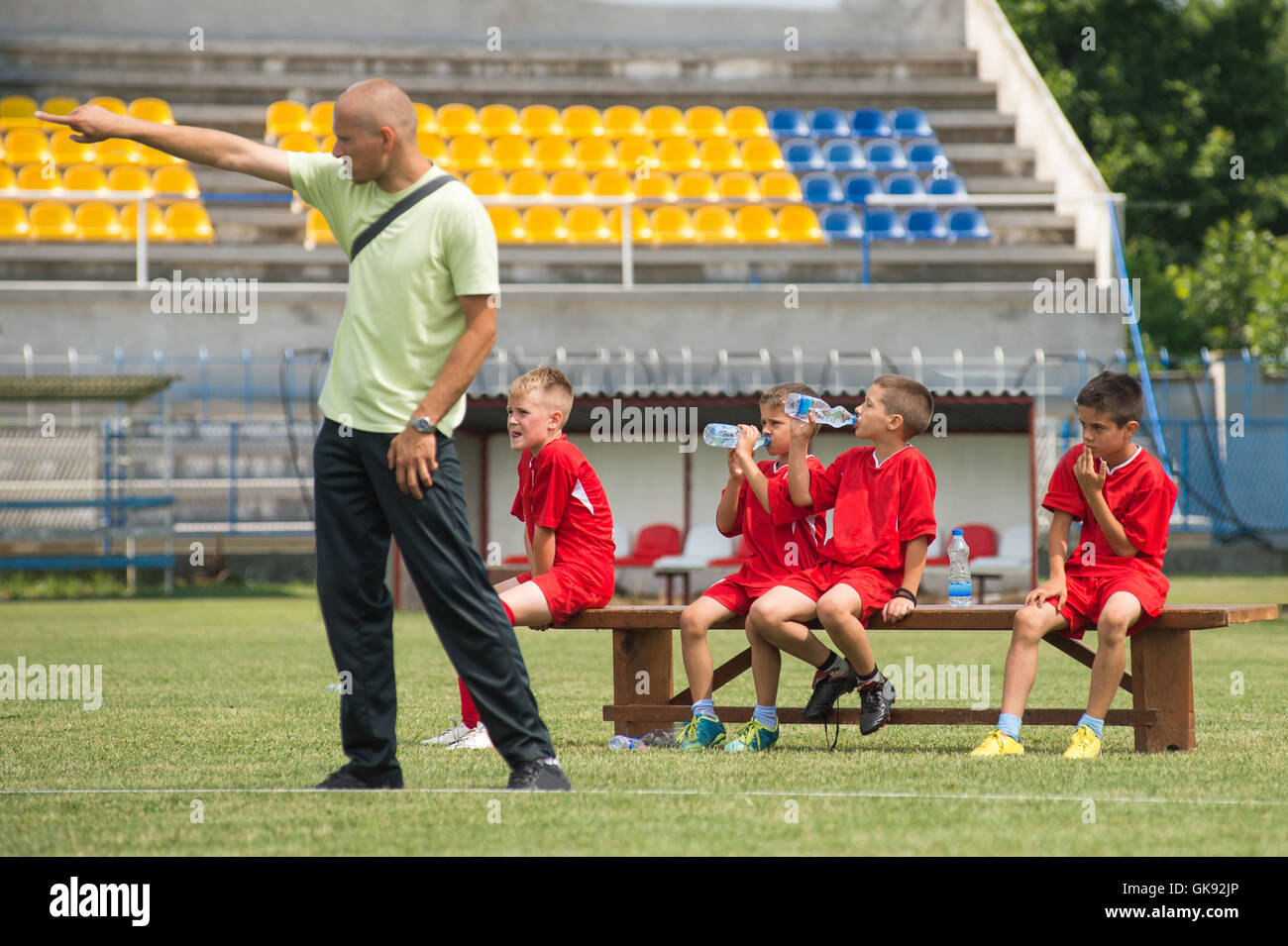 Kids waiting on a bench Stock Photo - Alamy