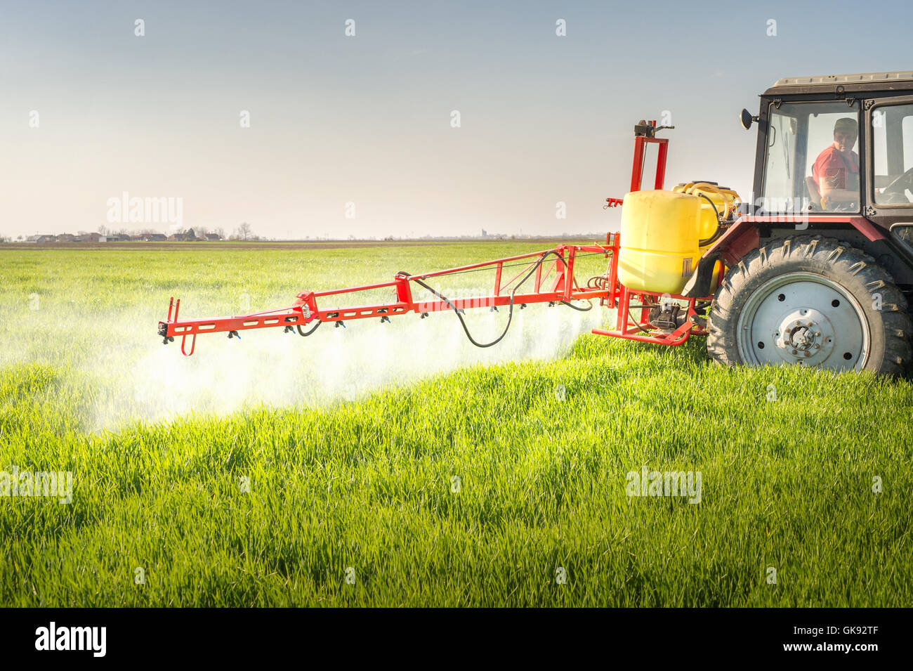 Tractor spraying wheat field with sprayer Stock Photo - Alamy