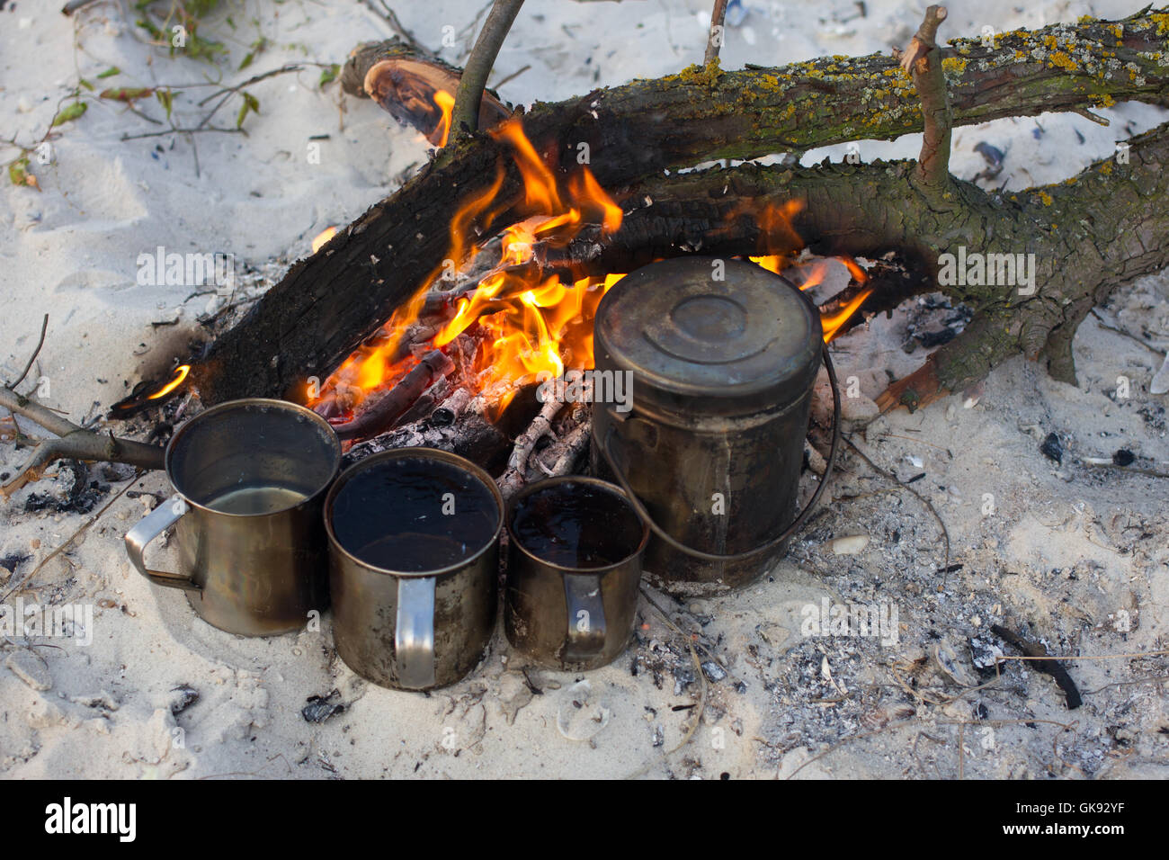The four cups and kettle heats water on the fire. Camping on beach ...
