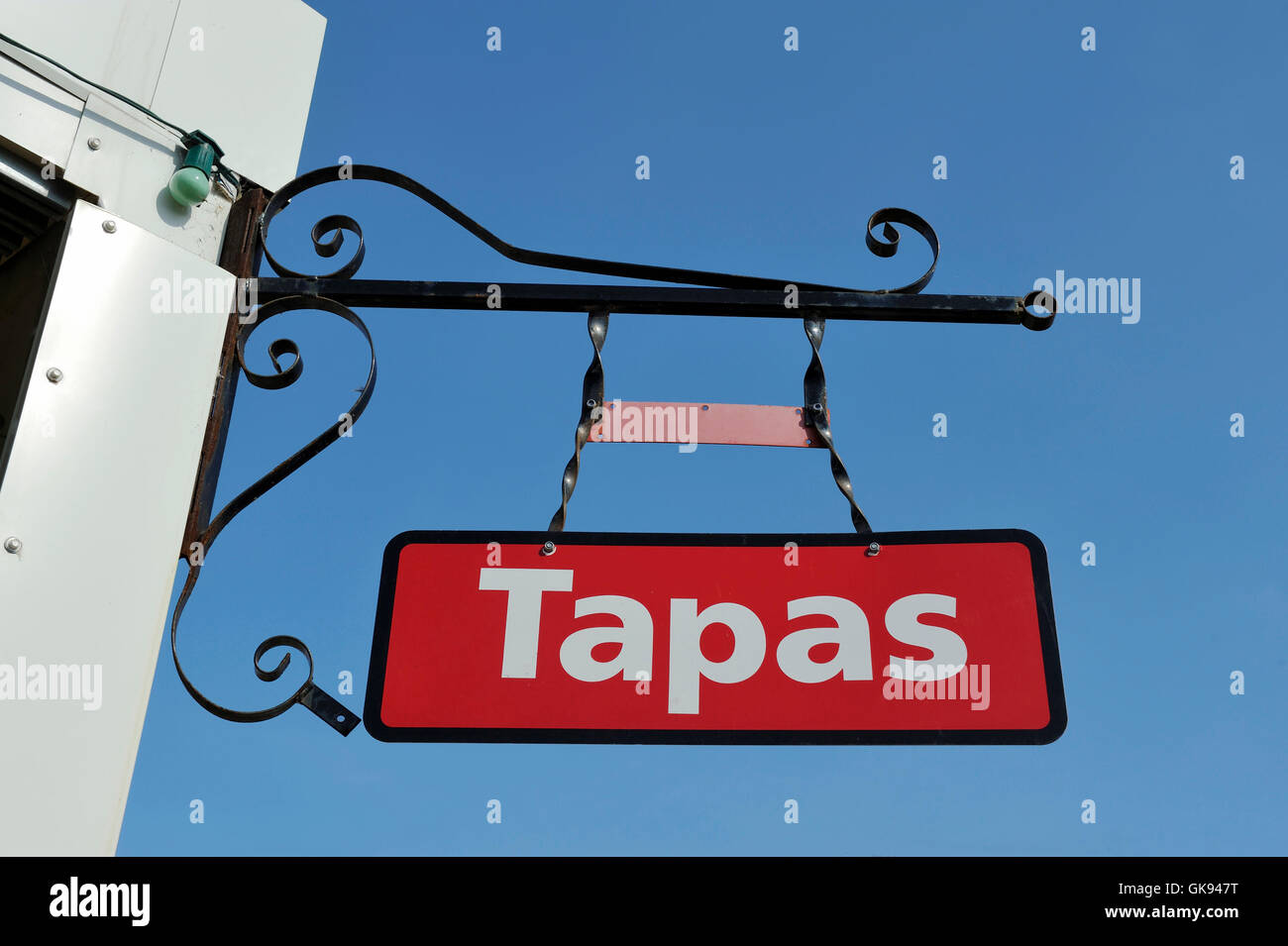 Sign with word Tapas at Spanish restaurant, against clear blue sky ...