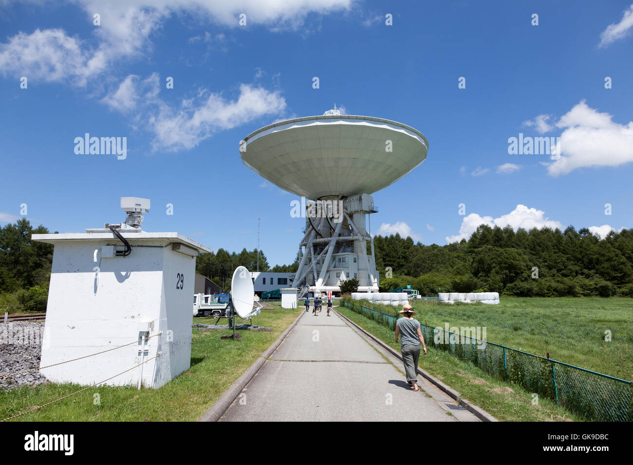 Tourists walk towards the 45 metre radio telescope at Nobeyama Radio ...