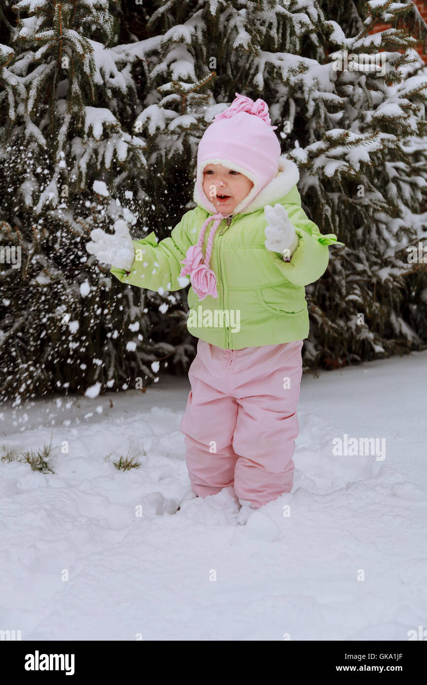 Little girl playing with snow Stock Photo - Alamy