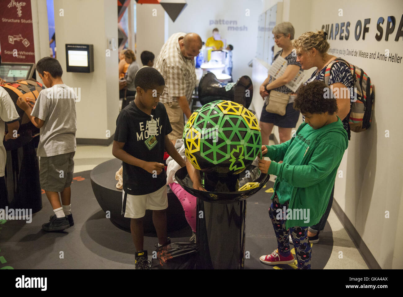 Children and adults explore mathematically based exhibits at the ...