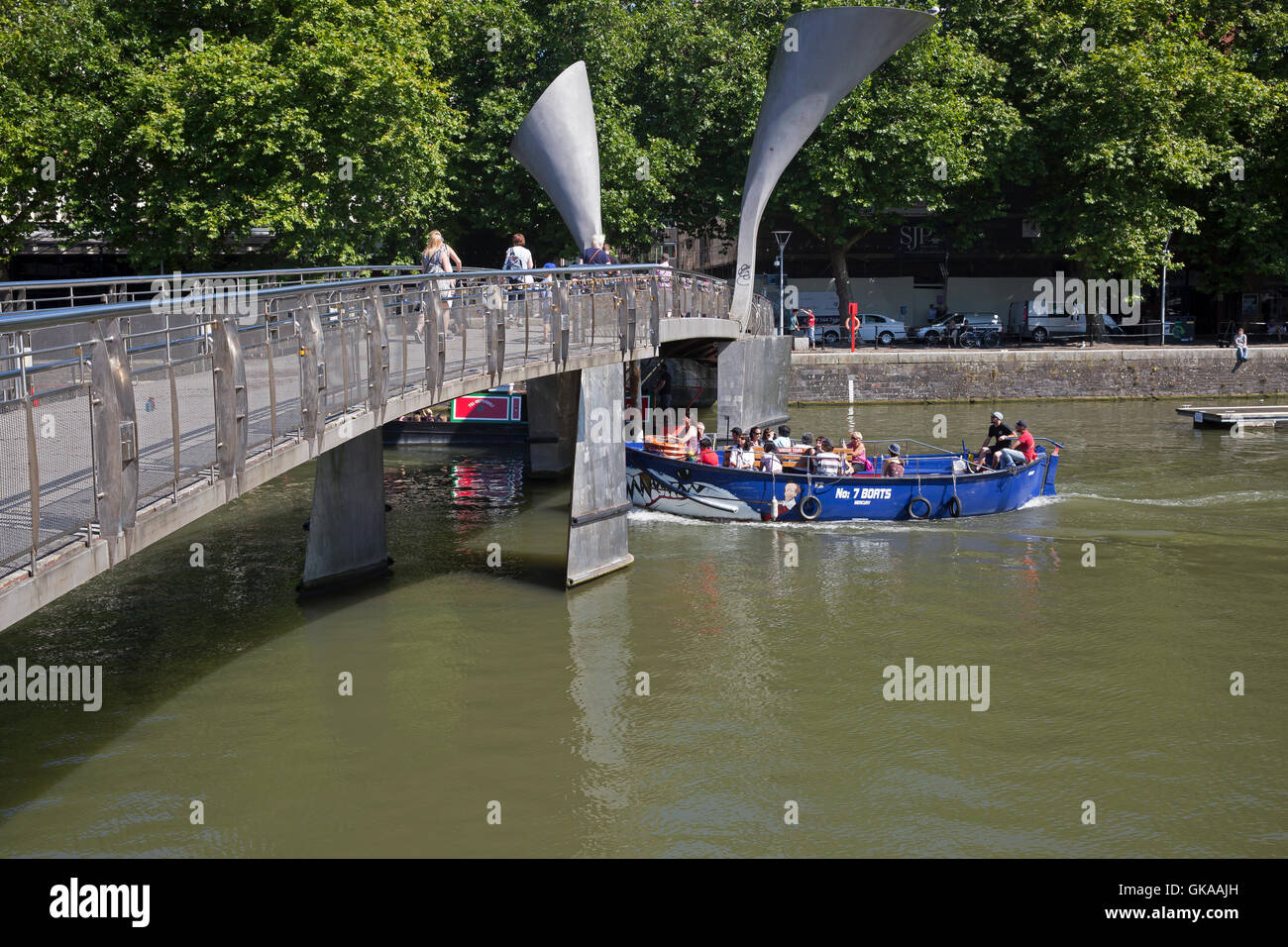 Small boat passes under a bridge by Bristol Waterfront on a summers day ...