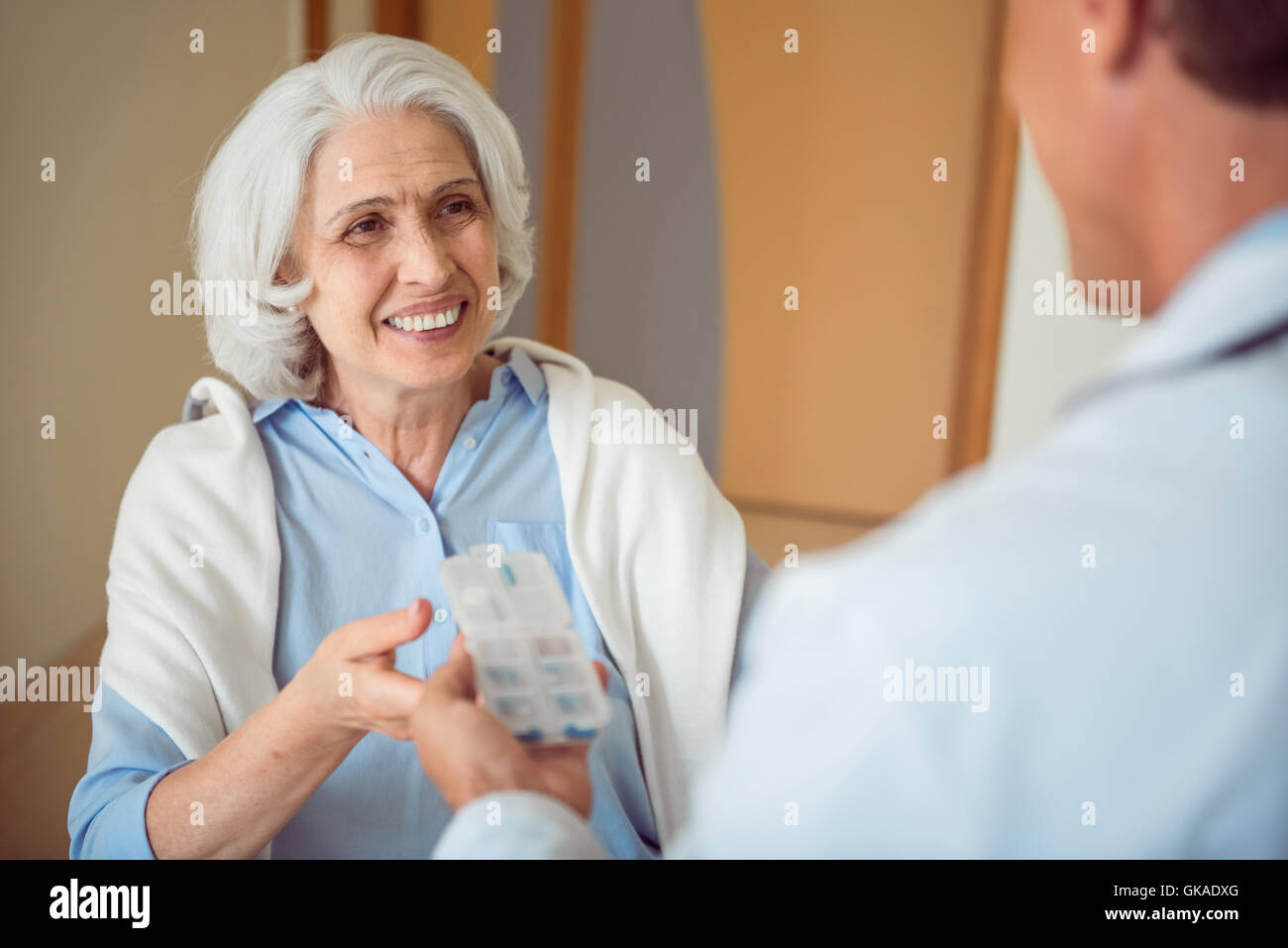 Nice doctor giving medicine his patient Stock Photo - Alamy