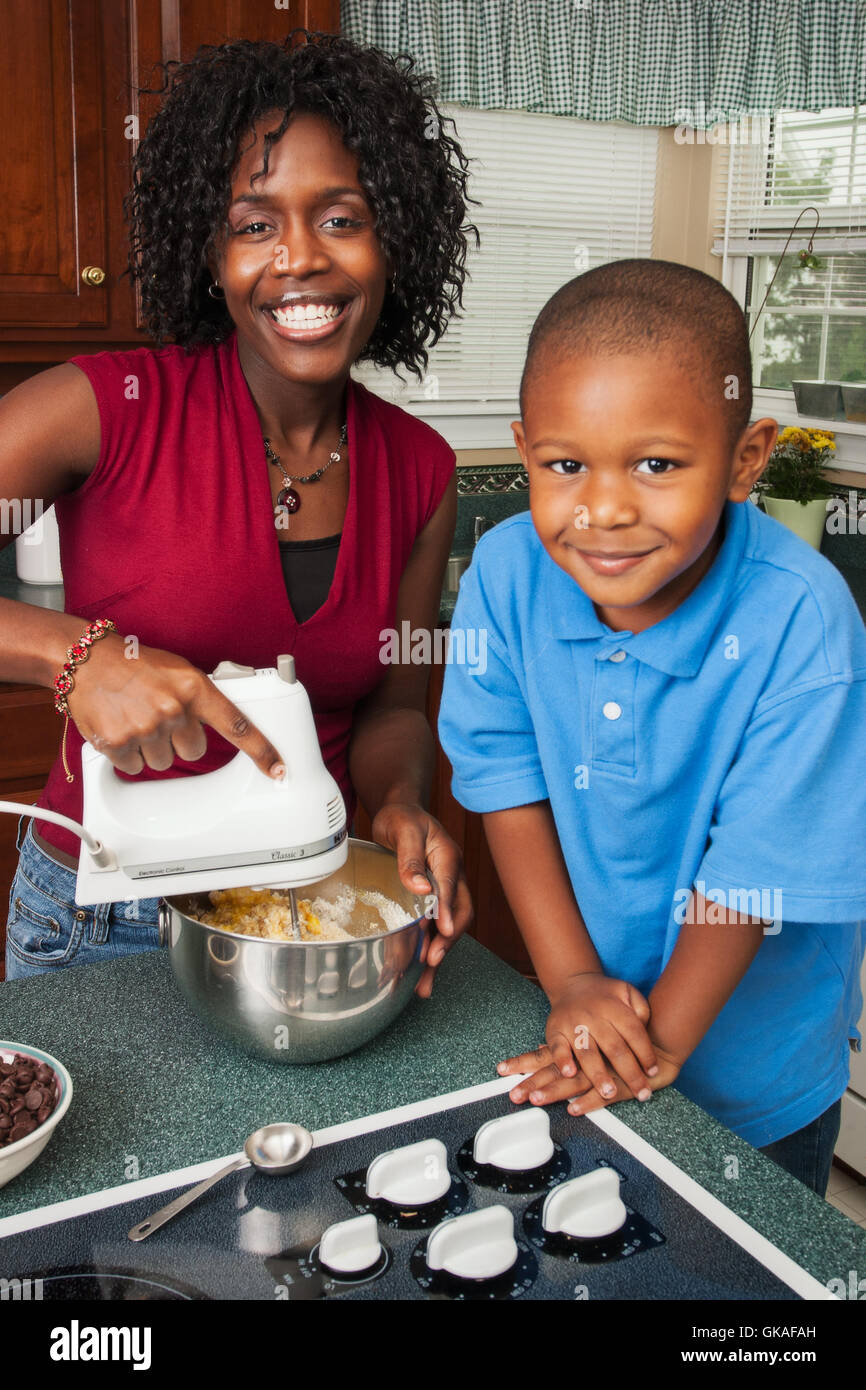 African American mother and son making cookies in kitchen and in ...