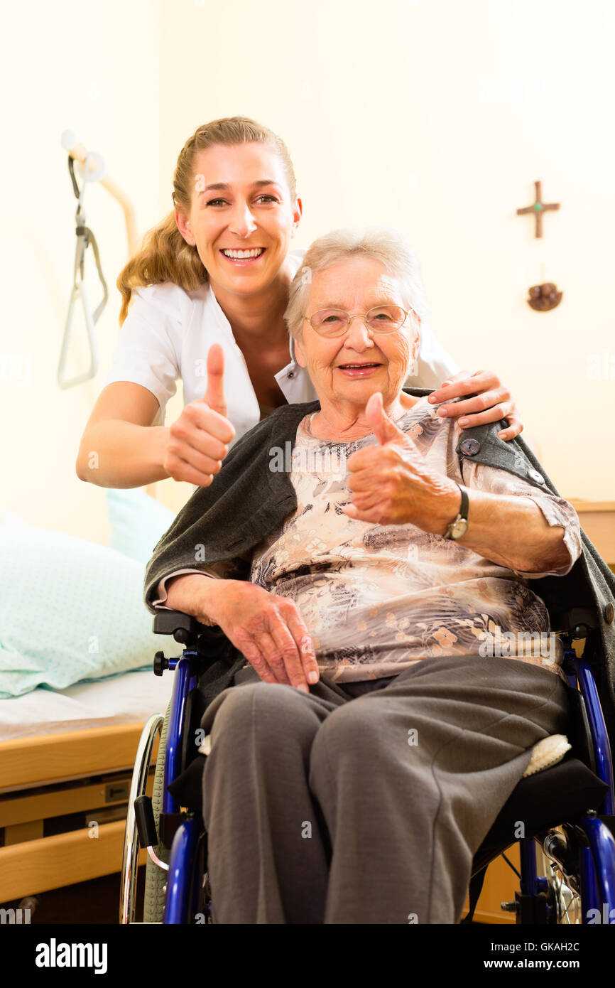 age and care - nurse and a senior citizen retirement home Stock Photo ...