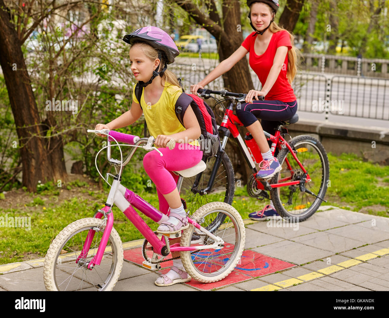 Girls children cycling on yellow bike lane Stock Photo - Alamy