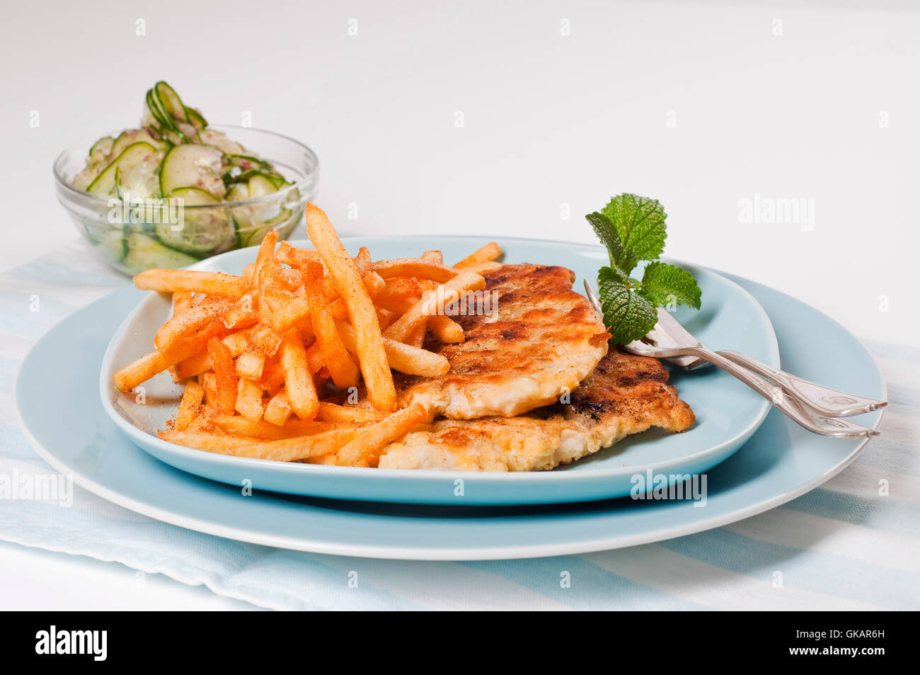 fish fillet with fries on blue plate Stock Photo - Alamy