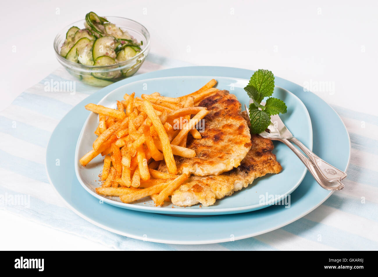fish fillet with fries on blue plate Stock Photo - Alamy