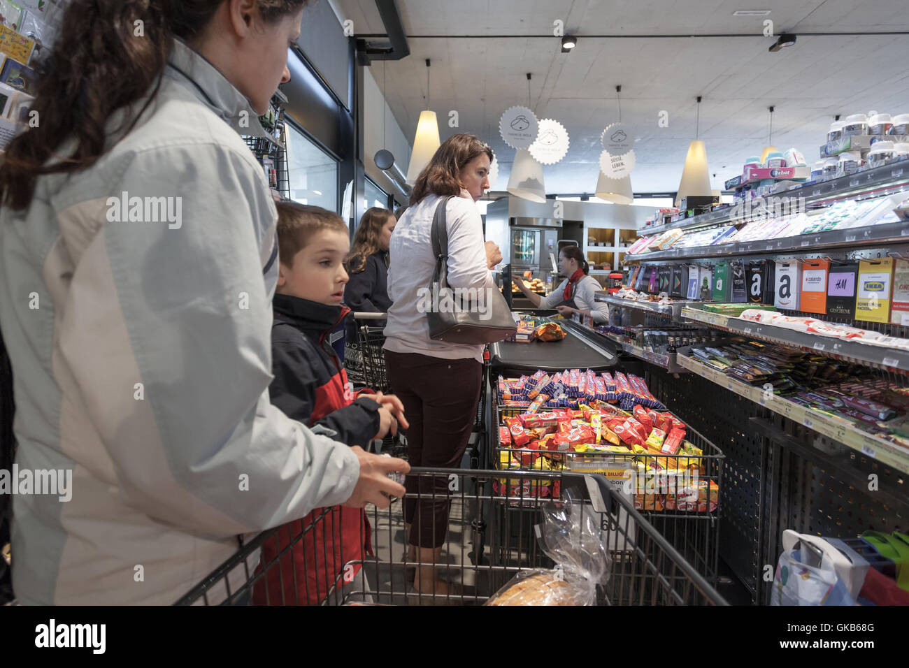 People making daily shoppings in a supermarket; waiting in line to pay ...