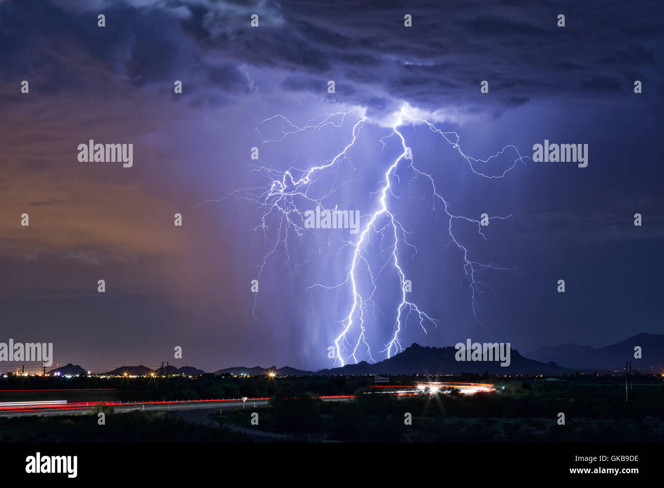 Bright lightning bolt strikes a mountain range in a monsoon storm near ...