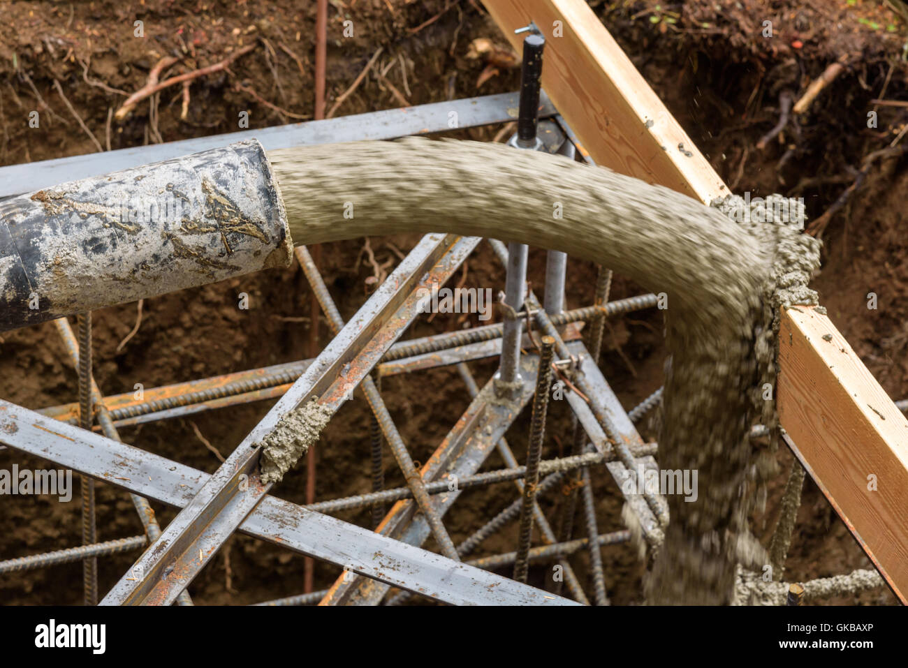 Concrete pumping hose filling foundation hole Stock Photo - Alamy