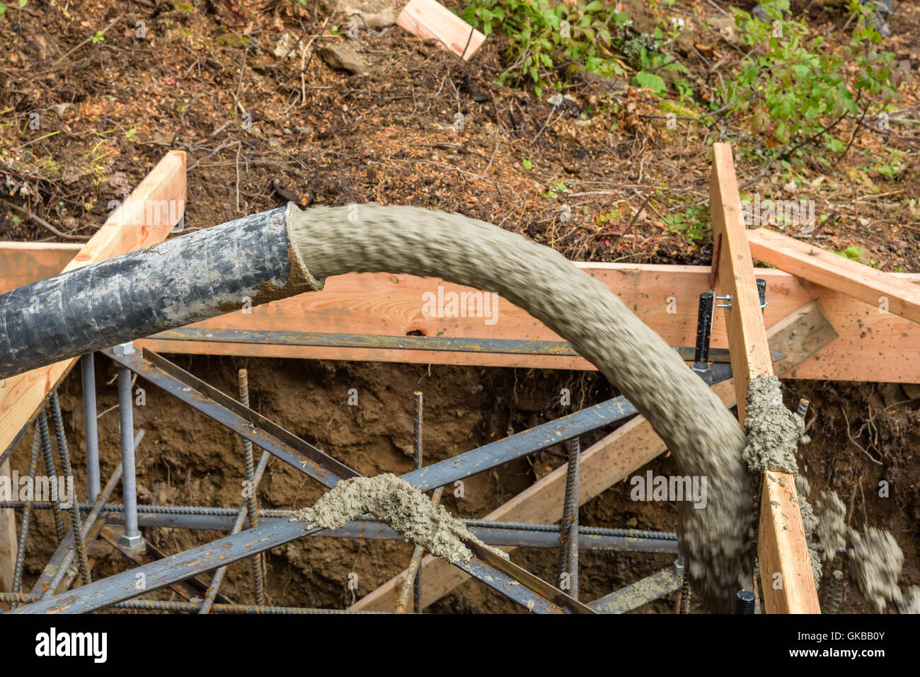 Concrete pumping hose filling foundation hole Stock Photo - Alamy