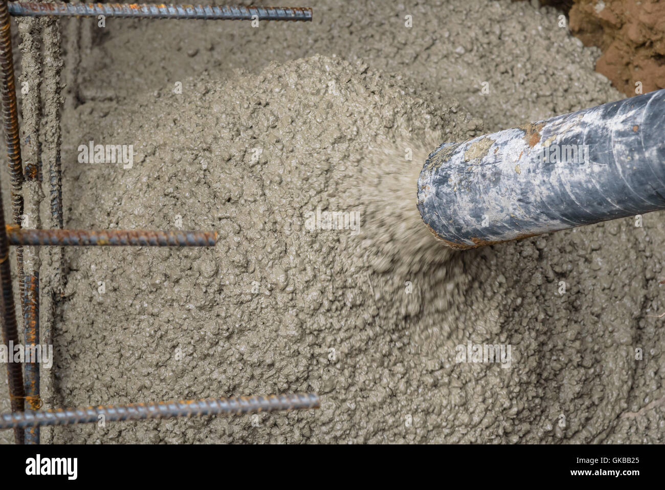 Concrete pumping hose filling foundation hole Stock Photo - Alamy