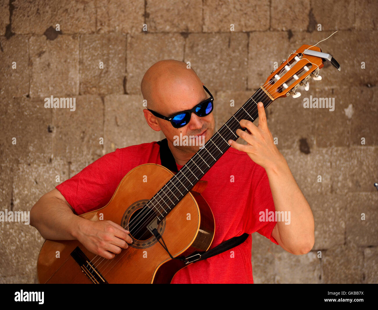 Classical guitarist in red shirt and blue reflective sunglasses playing ...