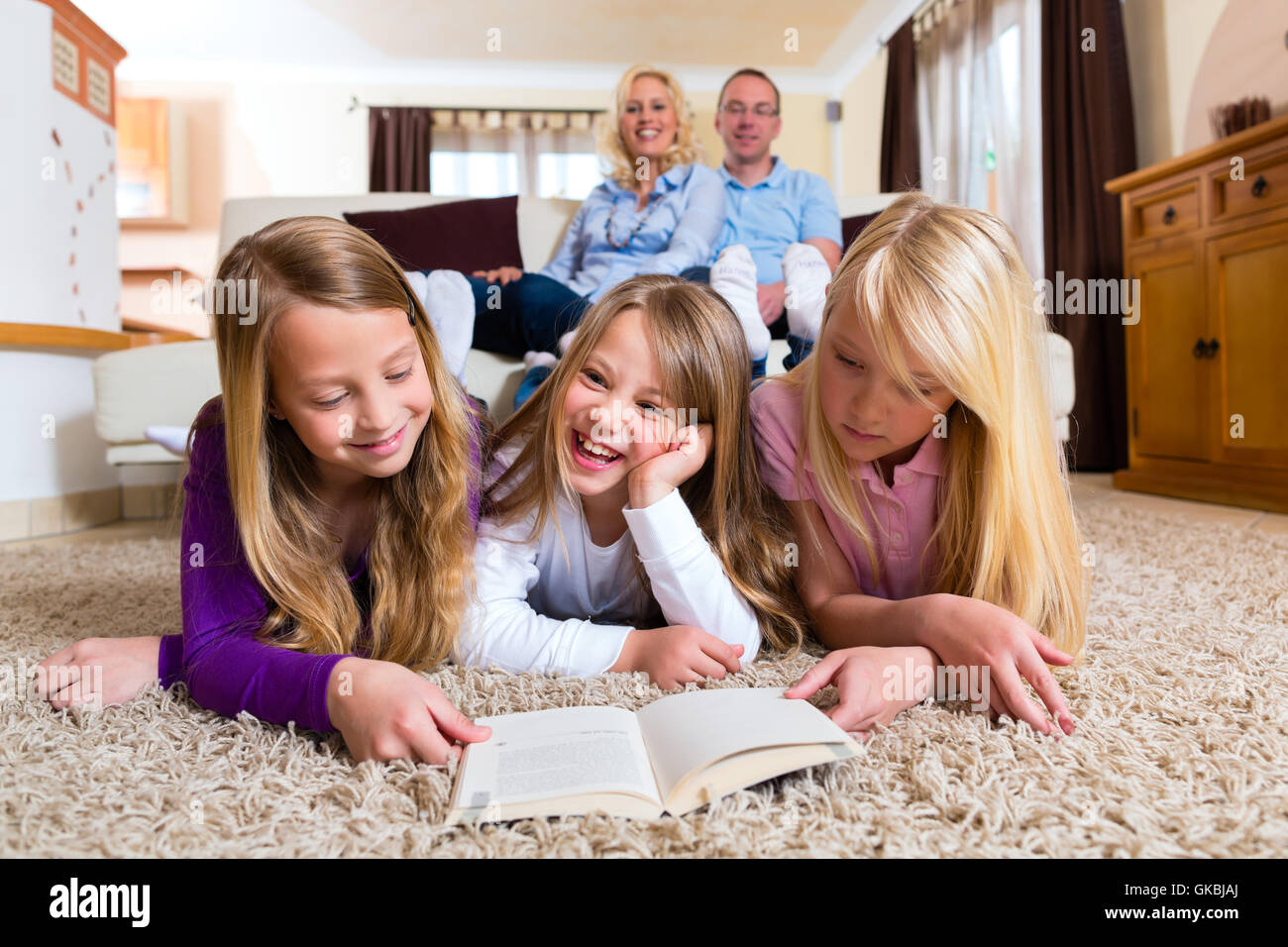 family reading a book together Stock Photo - Alamy