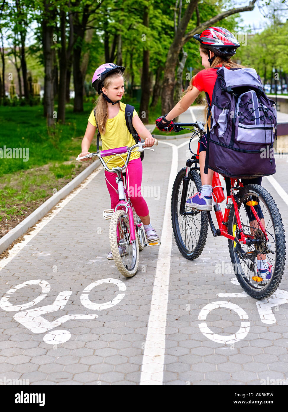 Girls children cycling on yellow bike lane Stock Photo - Alamy
