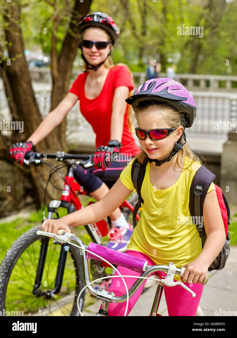 Girls children cycling on yellow bike lane Stock Photo - Alamy