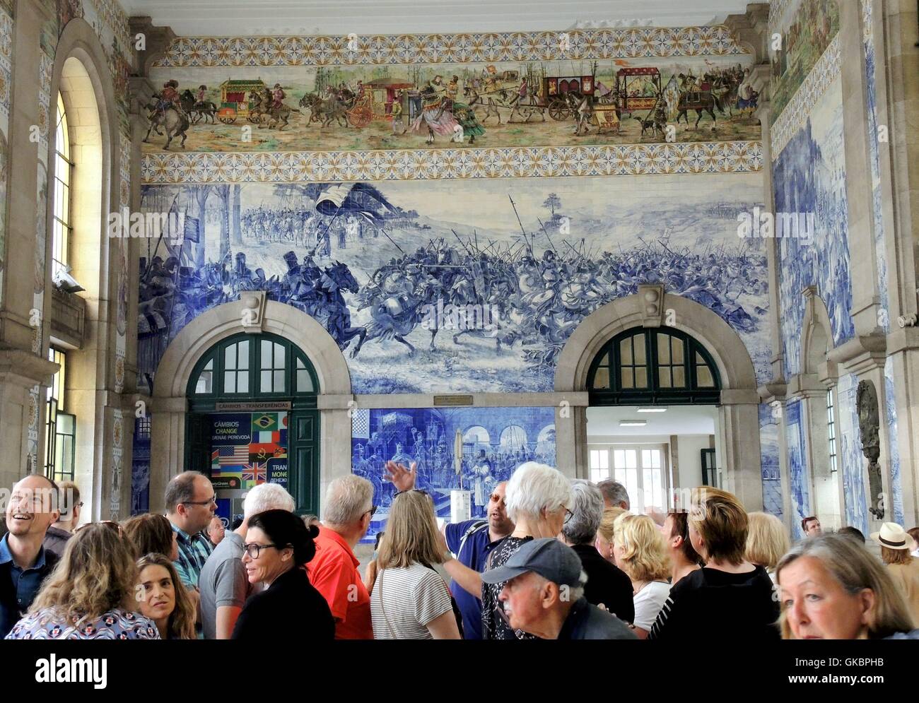 Tourists admire the murals made of ceramic tiles in the entrance hall ...