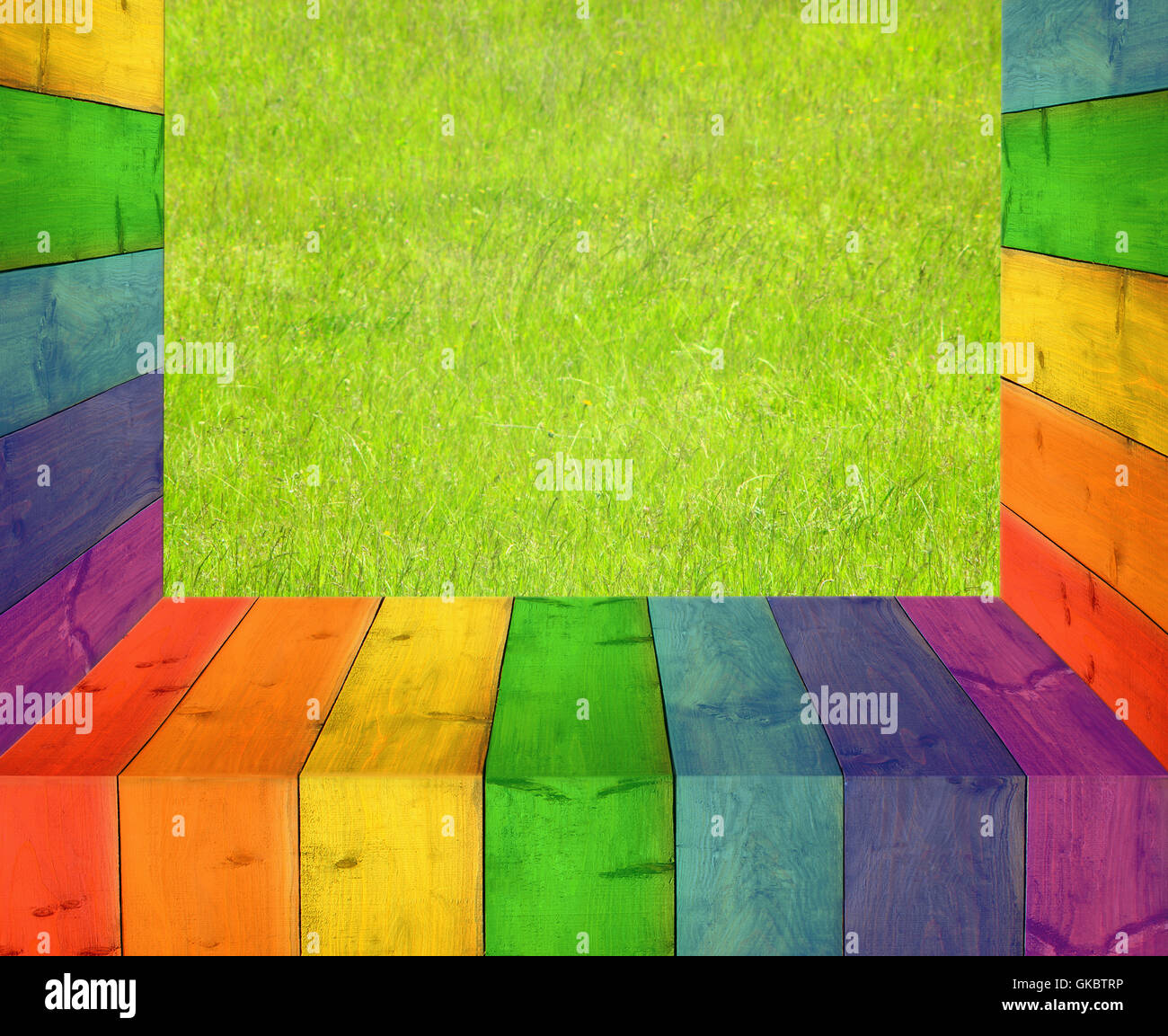 table from multicolored wooden boards with view to green grass ...