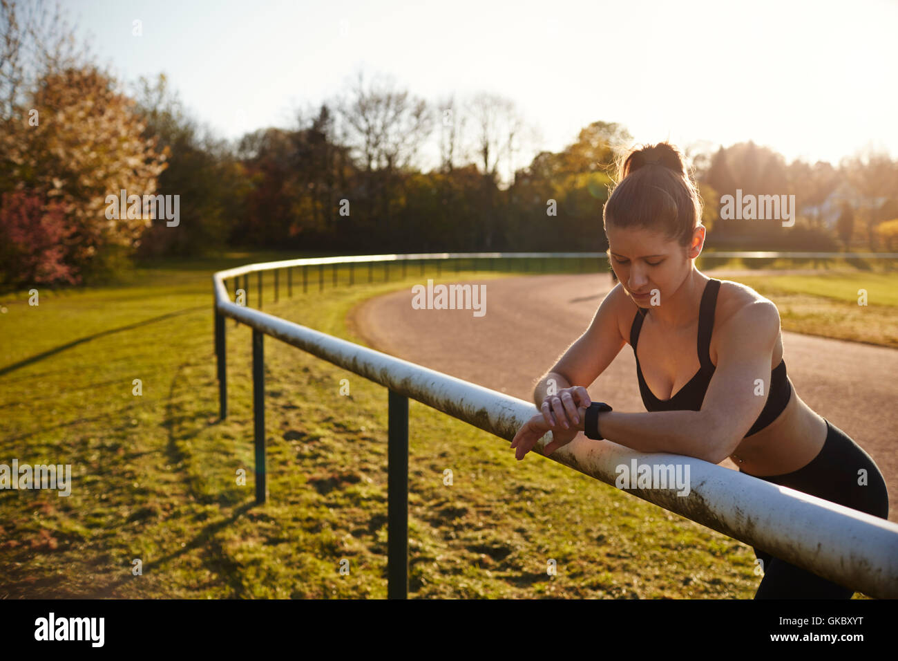 Young Woman Checks Activity Tracker During Outdoor Exercise Stock Photo ...