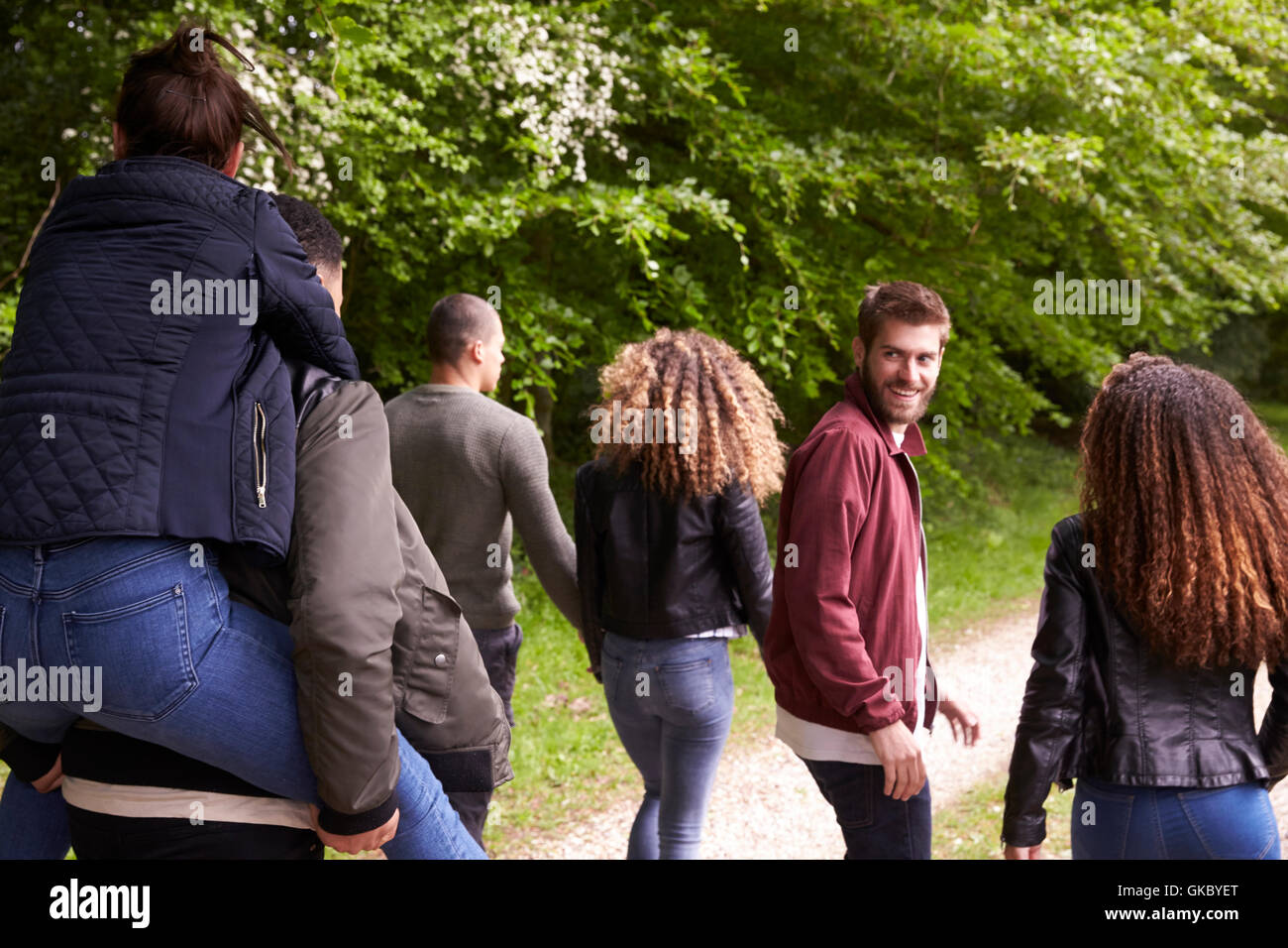 Young adult friends walking in a country lane, back view Stock Photo ...