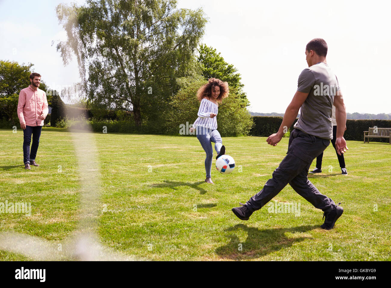 Adult friends having fun with a football on a playing field Stock Photo ...