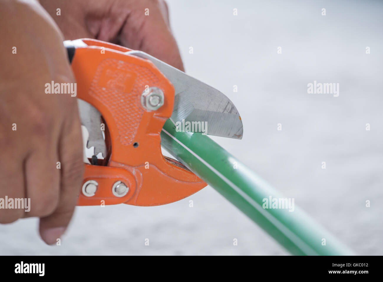 hand of working cutting green PPR plumbing pipe Stock Photo - Alamy
