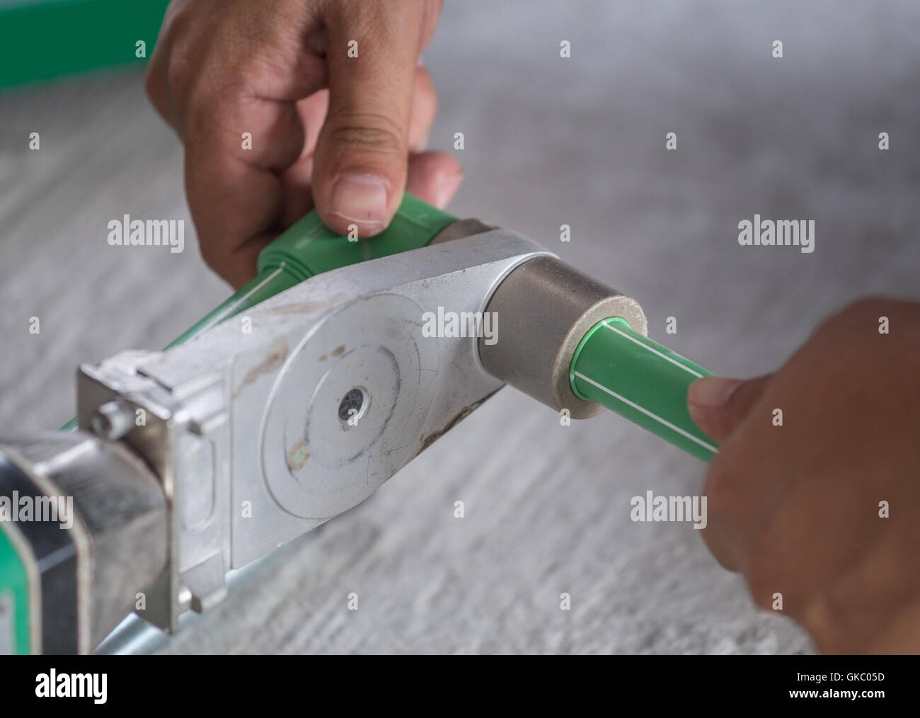 Plumber weld two pieces of green PPR pipe Stock Photo - Alamy