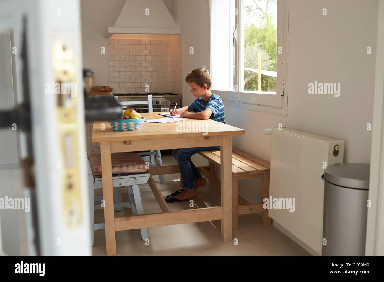 Boy Doing Homework Sitting At Kitchen Table Stock Photo - Alamy