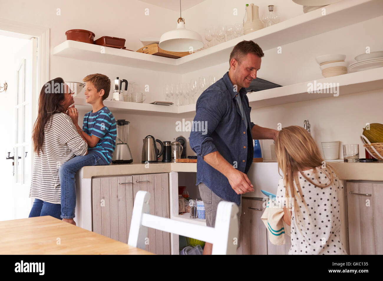 Children Helping Parents In Kitchen With Chores Stock Photo - Alamy