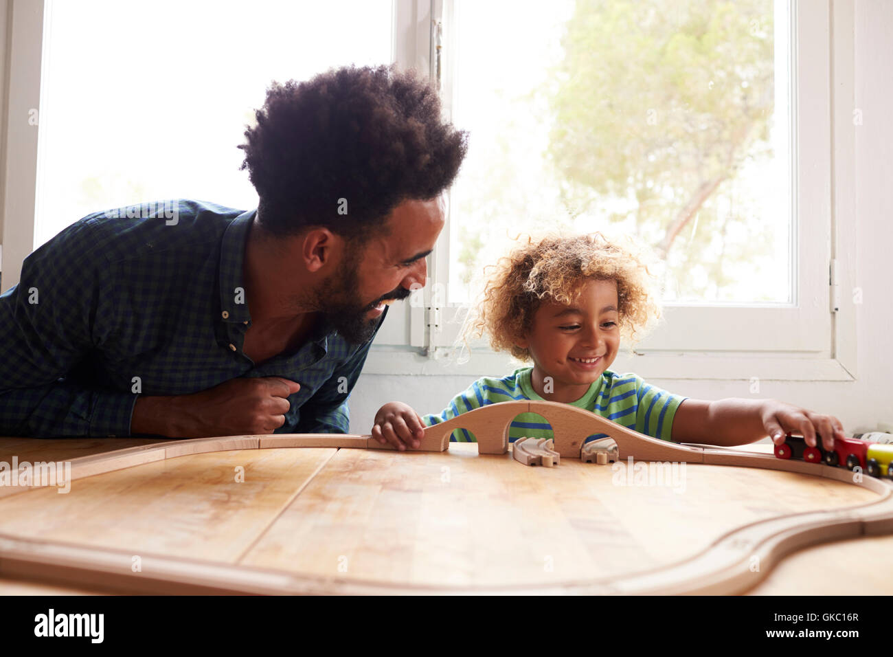 Father And Son Playing With Toy Train Set Stock Photo - Alamy