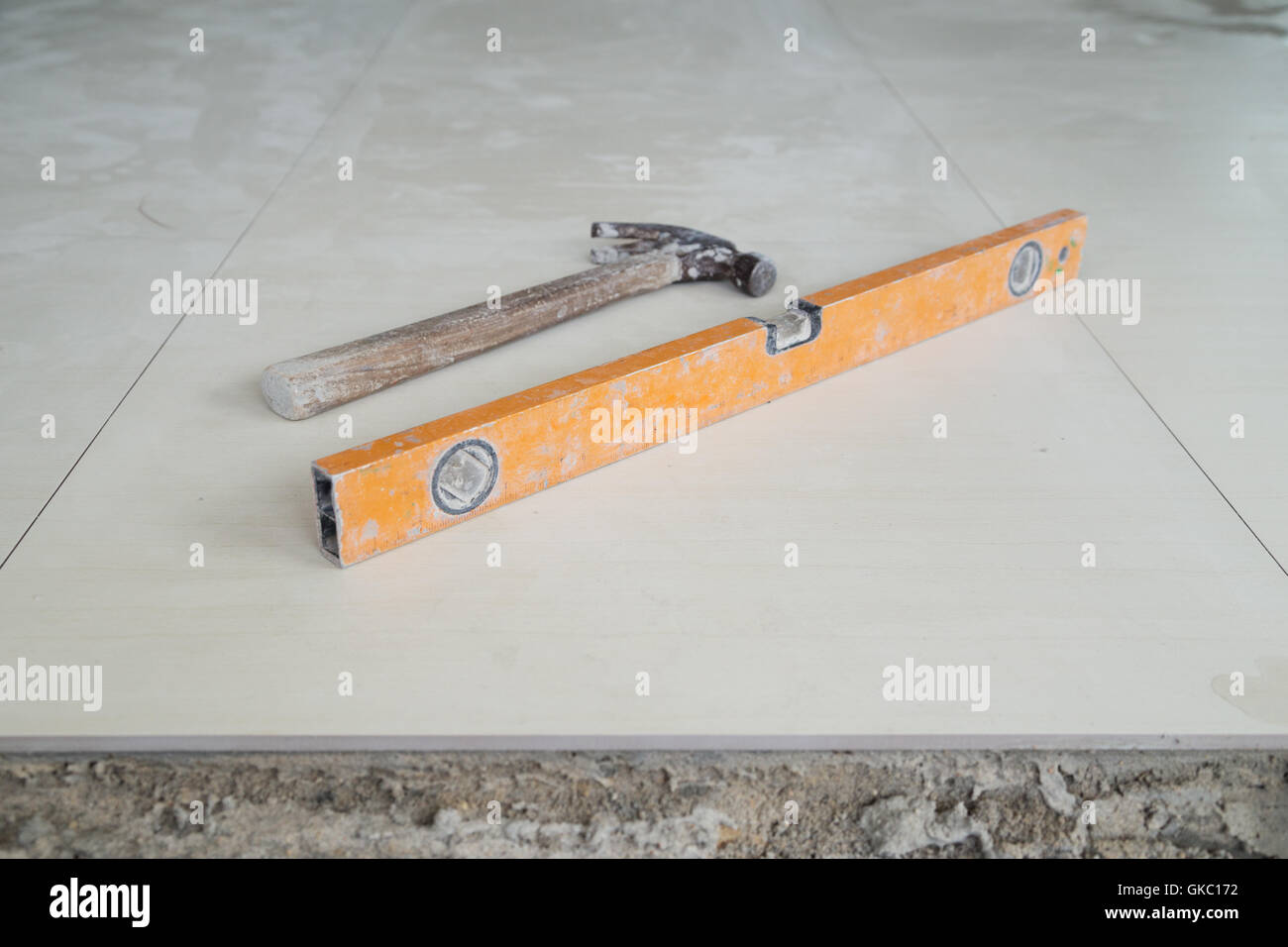 spirit level and hammer (tool for working tile) at construction site ...