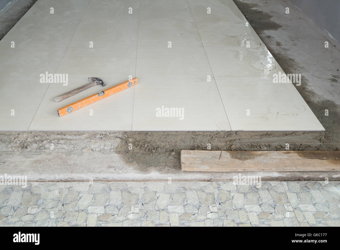 spirit level and hammer (tool for working tile) at construction site ...